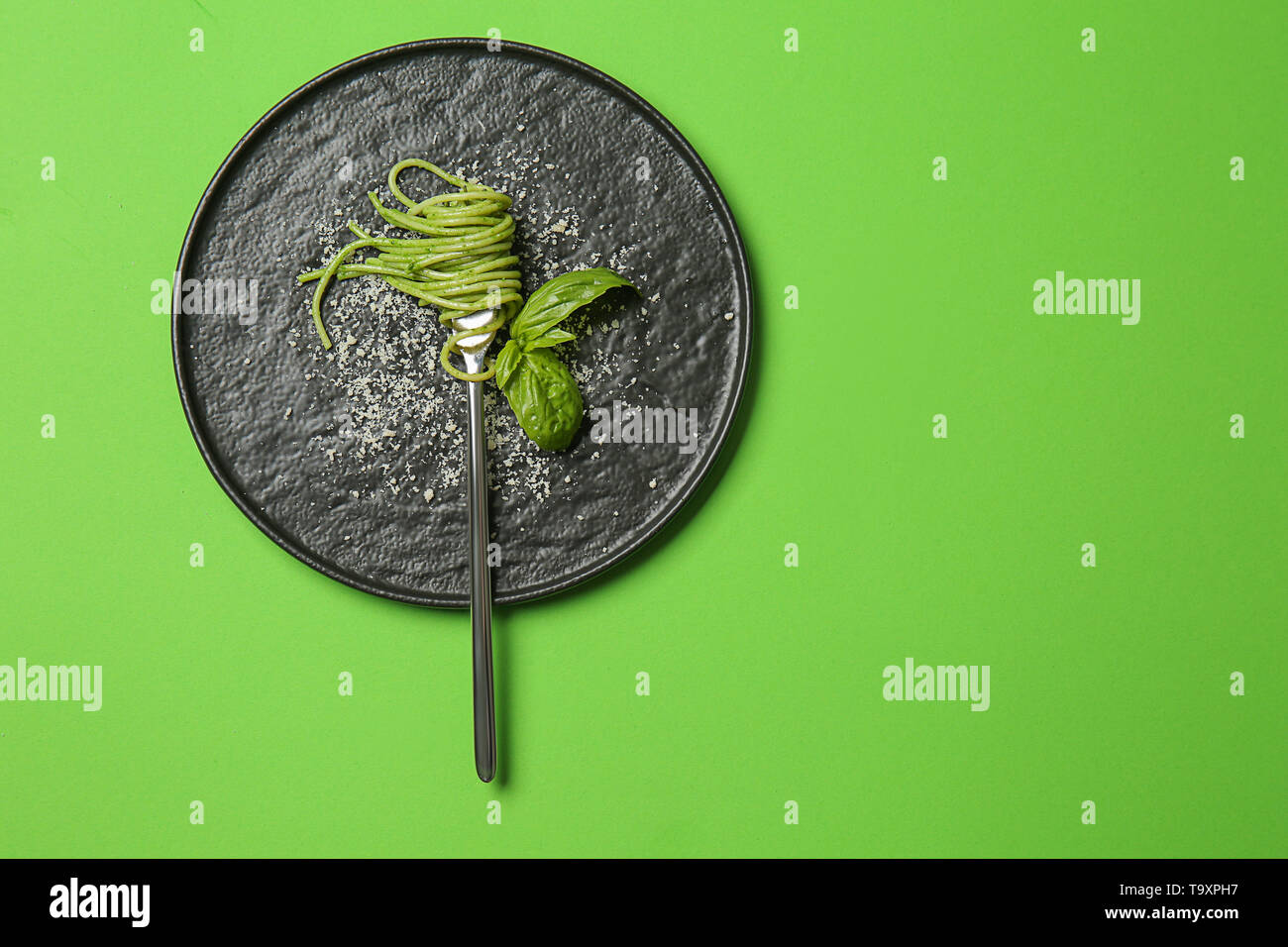 Plate with tasty pesto pasta on color background Stock Photo - Alamy
