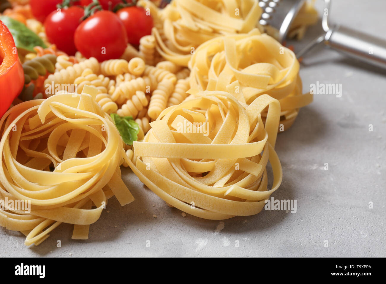 Raw pasta on grey background Stock Photo - Alamy