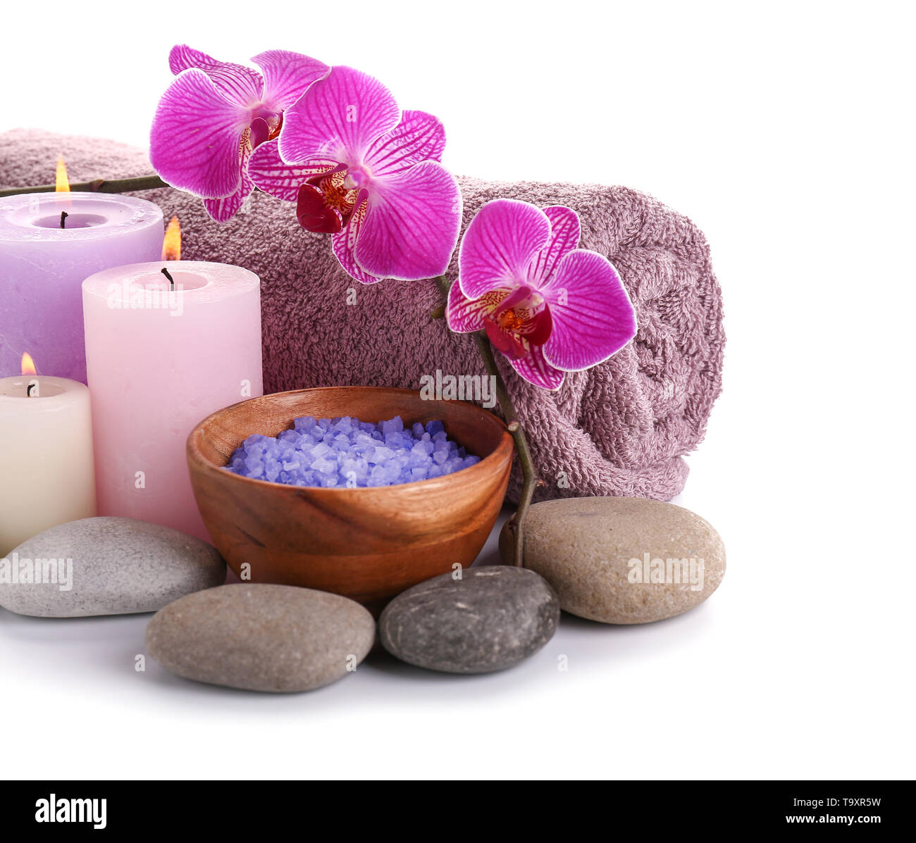 Beautiful spa composition with stones, towel, sea salt and candles on ...