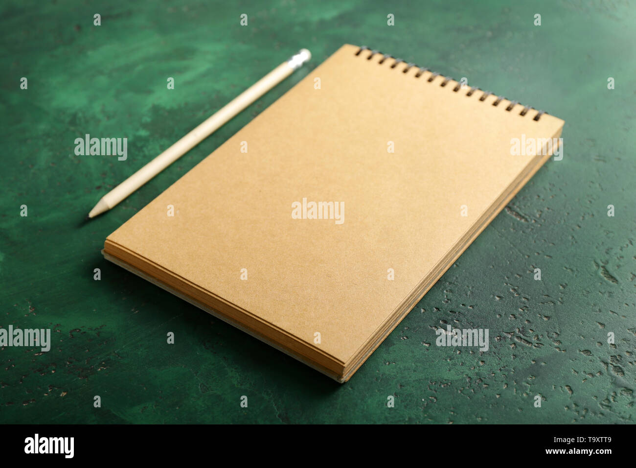 Blank notebook and pencil on color background Stock Photo - Alamy