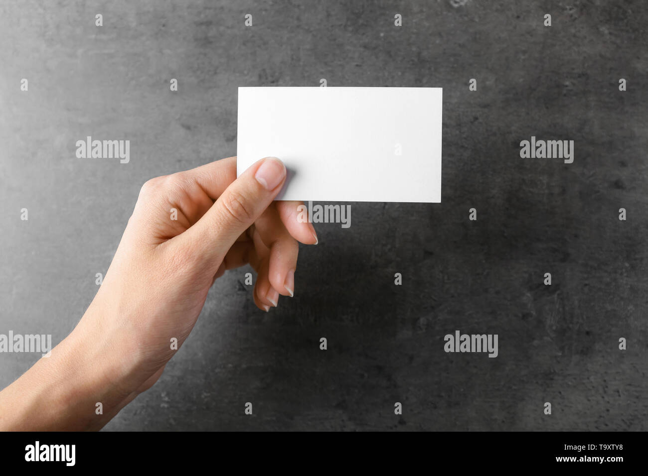 Female hand with blank business card on grey background Stock Photo - Alamy