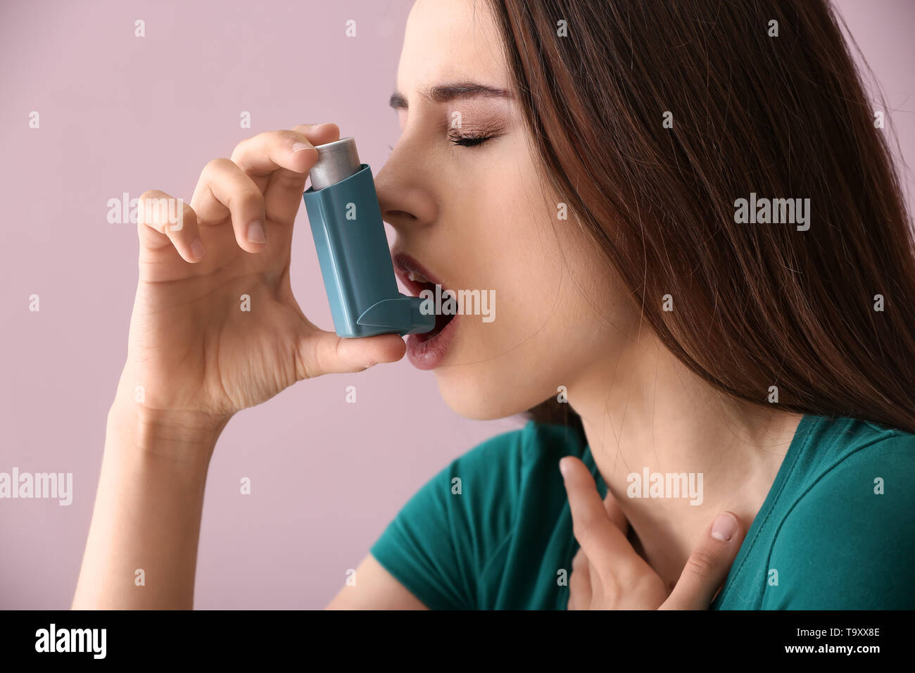 Young woman with inhaler having asthma attack on color background Stock ...