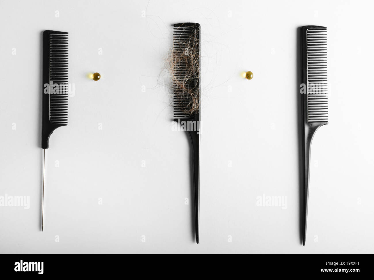 Combs with fallen down hair and fish oil pills on white background ...