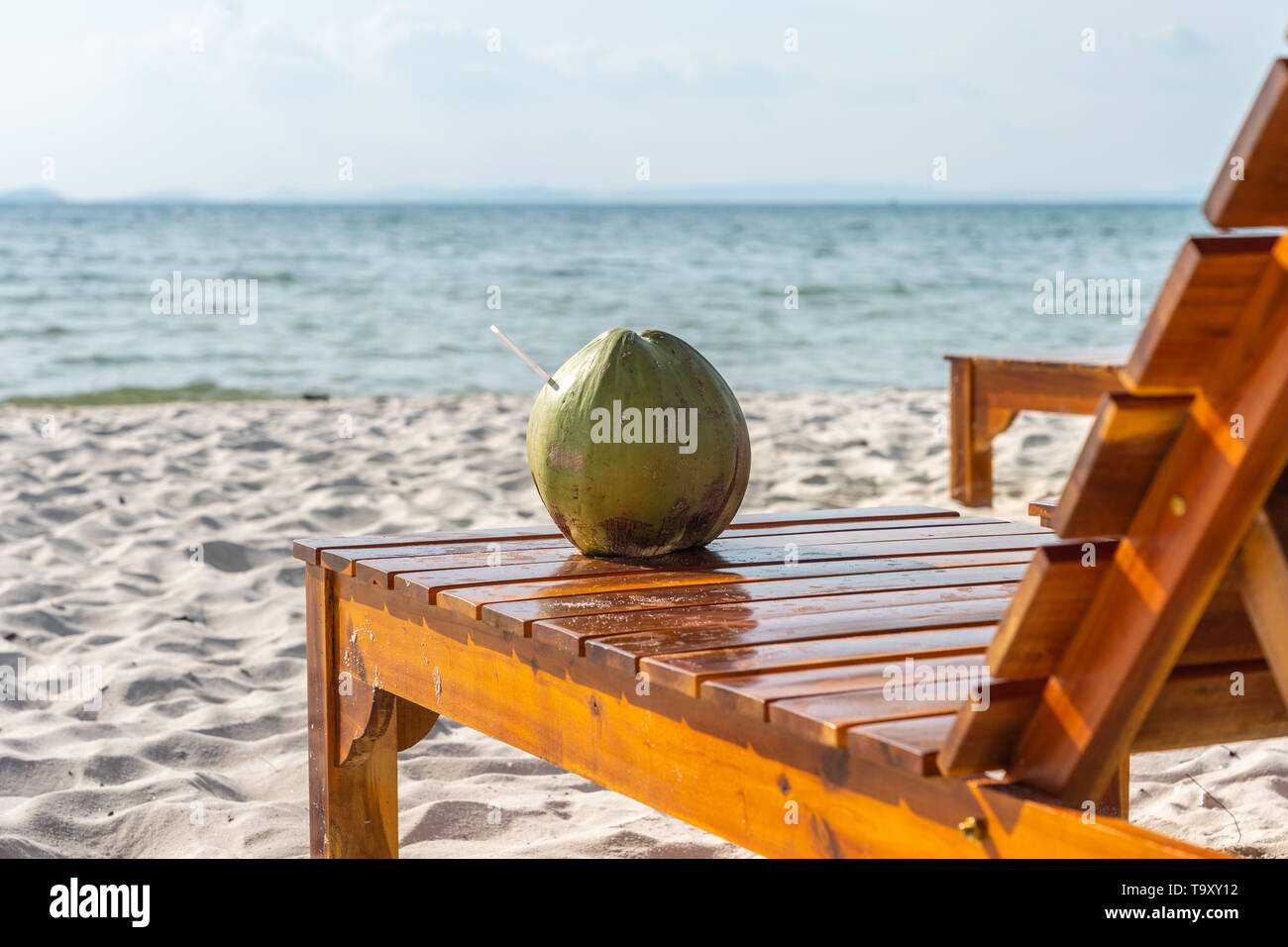 Coconut tropical drink on chair on the white sand beach Stock Photo - Alamy