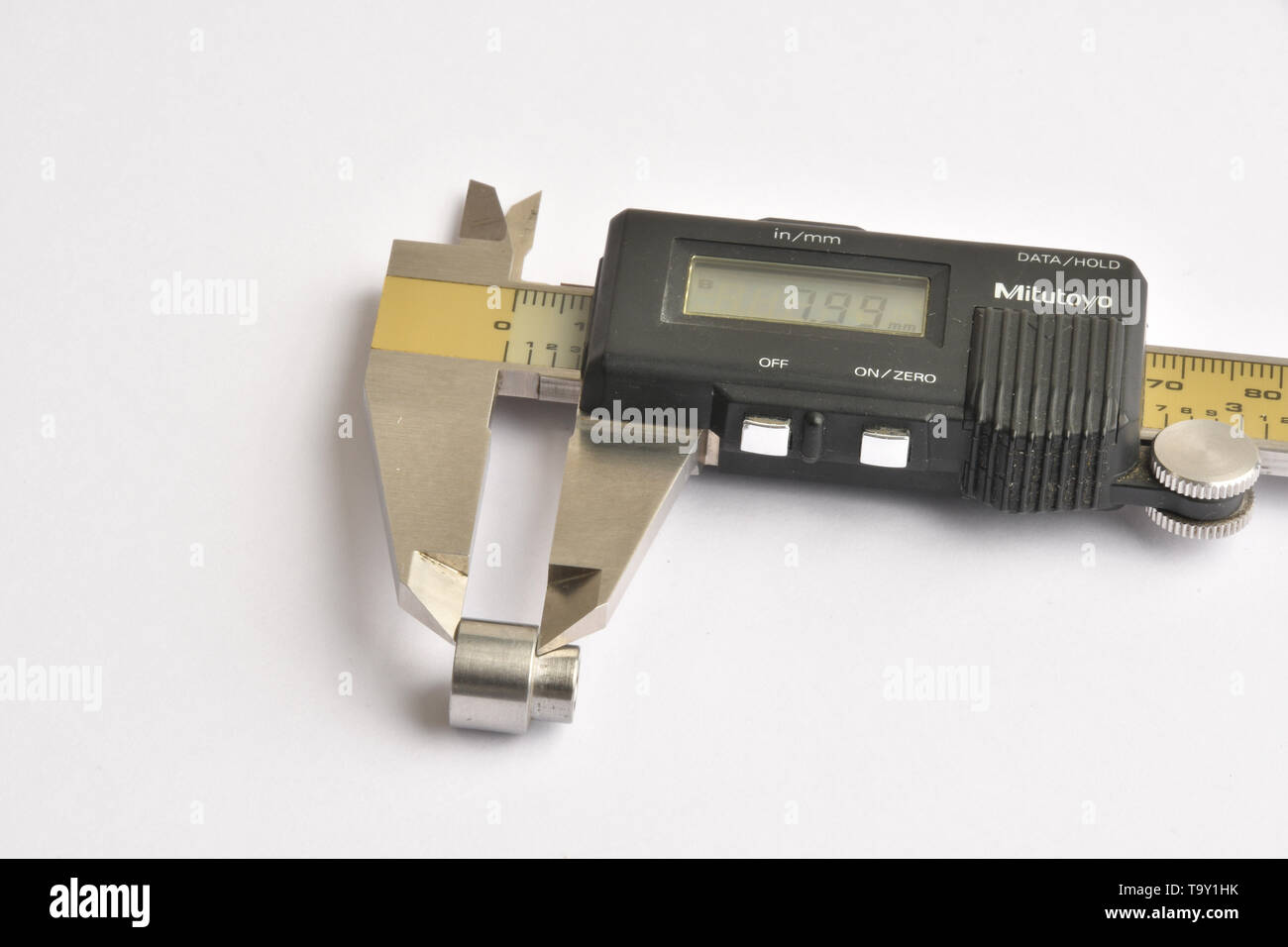 Digital vernier caliper measuring the length of a turned component ...