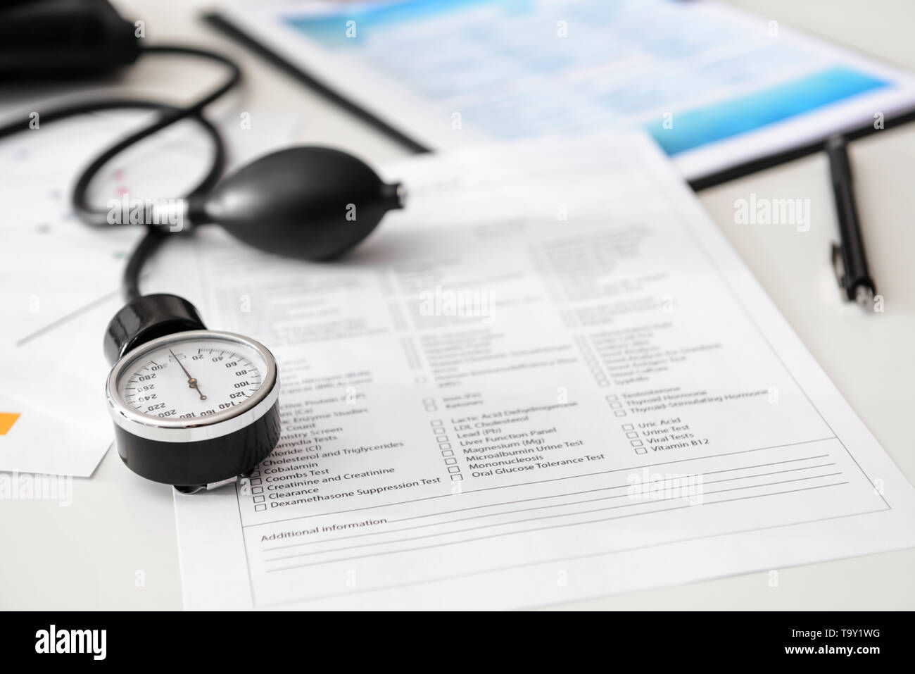 Document with results of laboratory test and sphygmomanometer on table ...