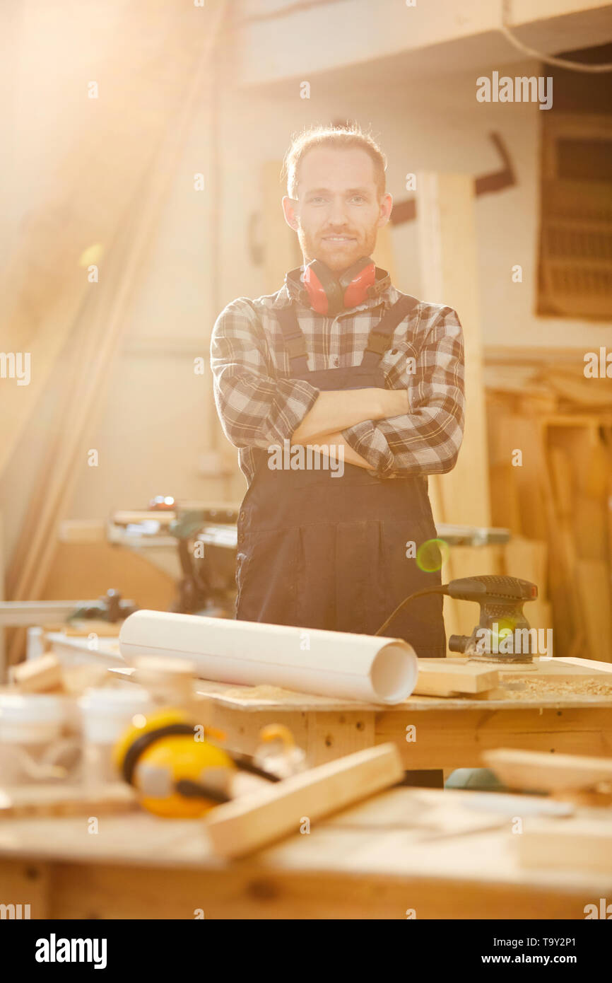 Waist up portrait of contemporary carpenter looking at camera while ...