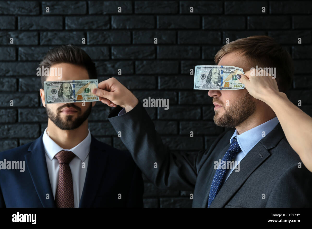 Blind businessmen with bribe on dark brick background. Concept of ...