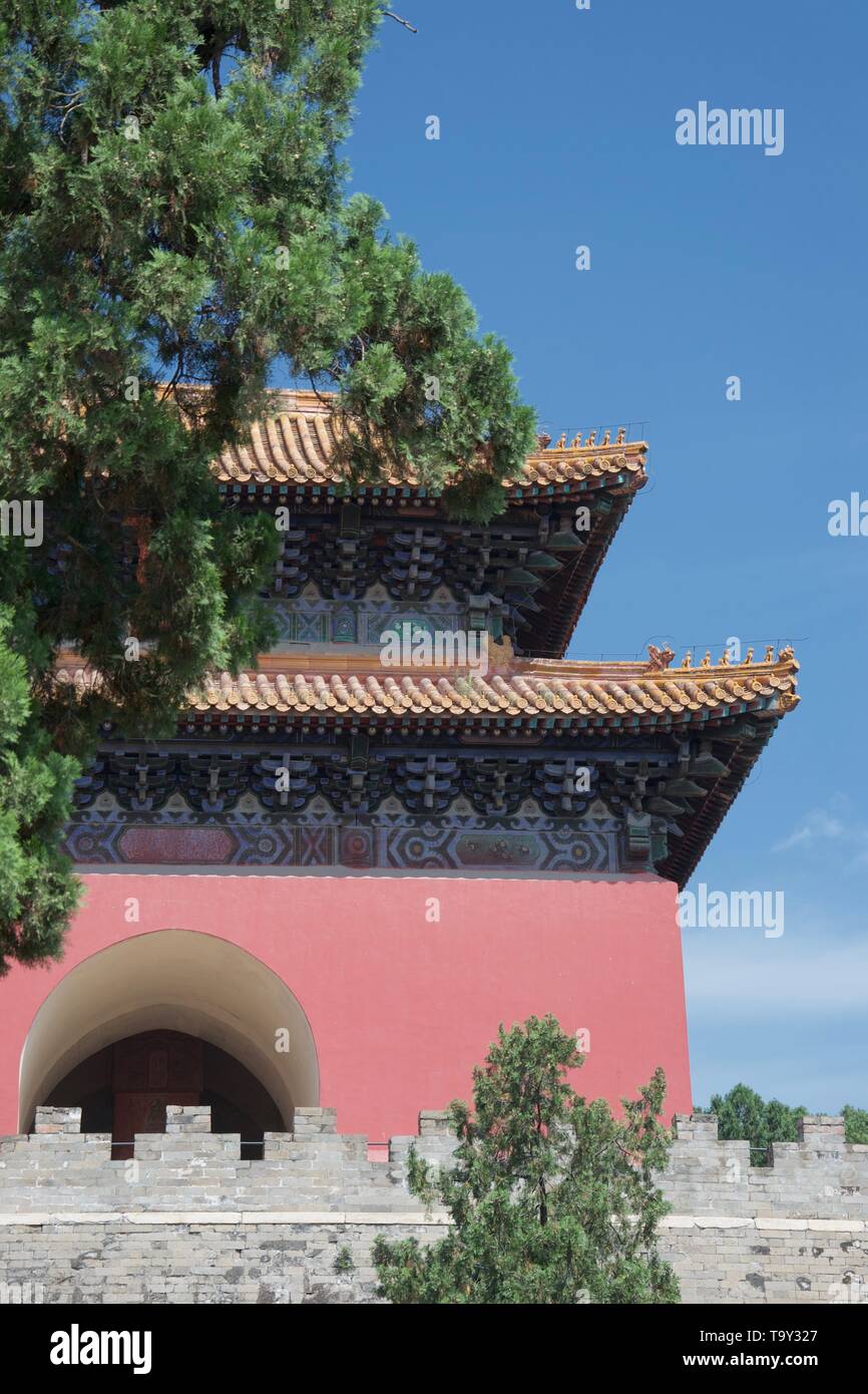 Pink painted Chinese temple against blue sky, partially obscured by ...