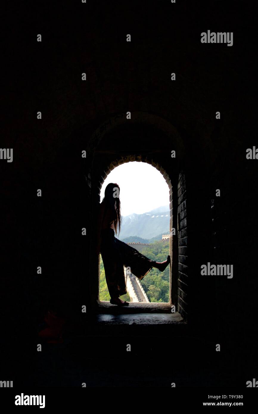 A long haired lady wearing flared trousers (flares) stands in a doorway ...