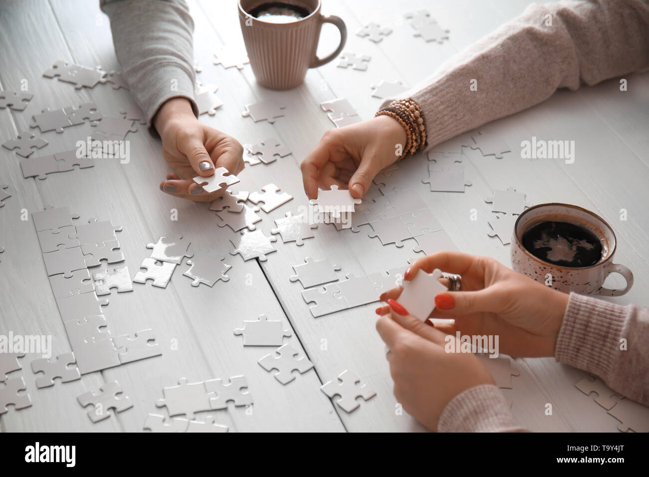 Hands doing puzzle hi-res stock photography and images - Alamy