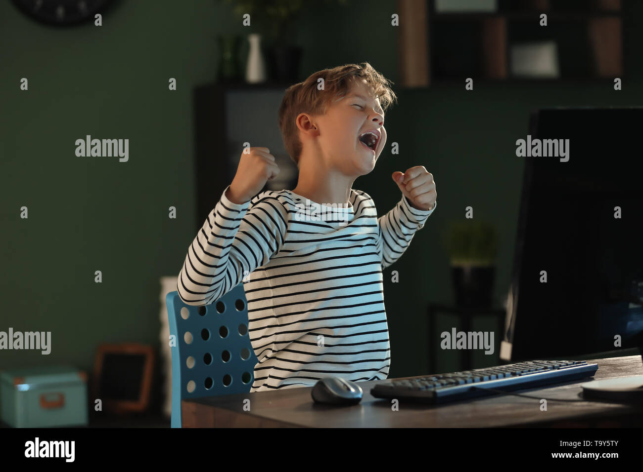 Happy little boy after winning computer game at home Stock Photo - Alamy