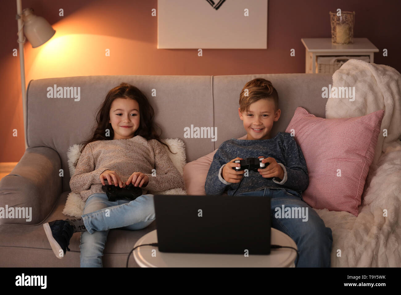 Cute little children playing computer game at home Stock Photo - Alamy
