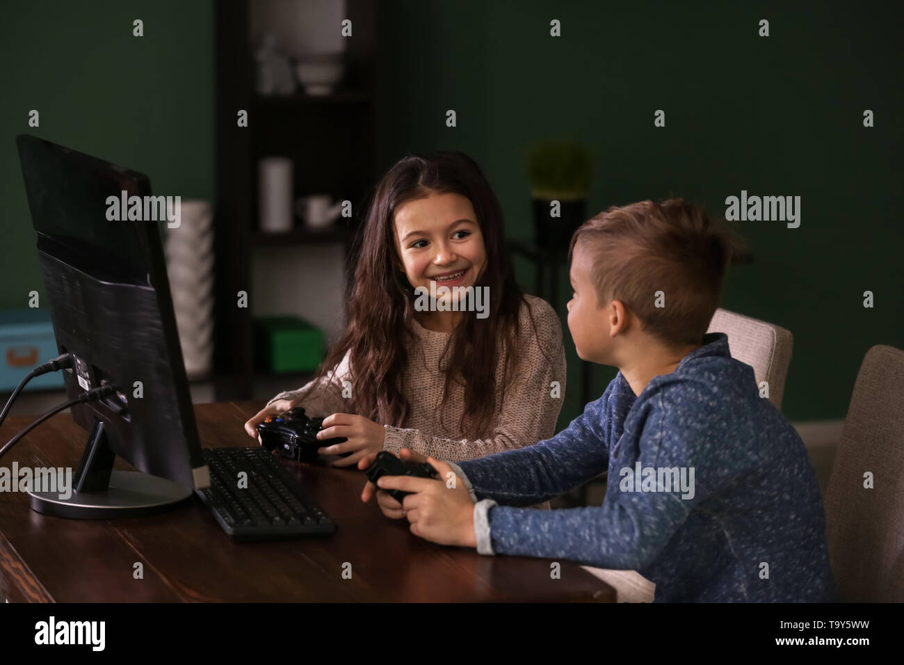 Cute little children playing computer game at home Stock Photo - Alamy
