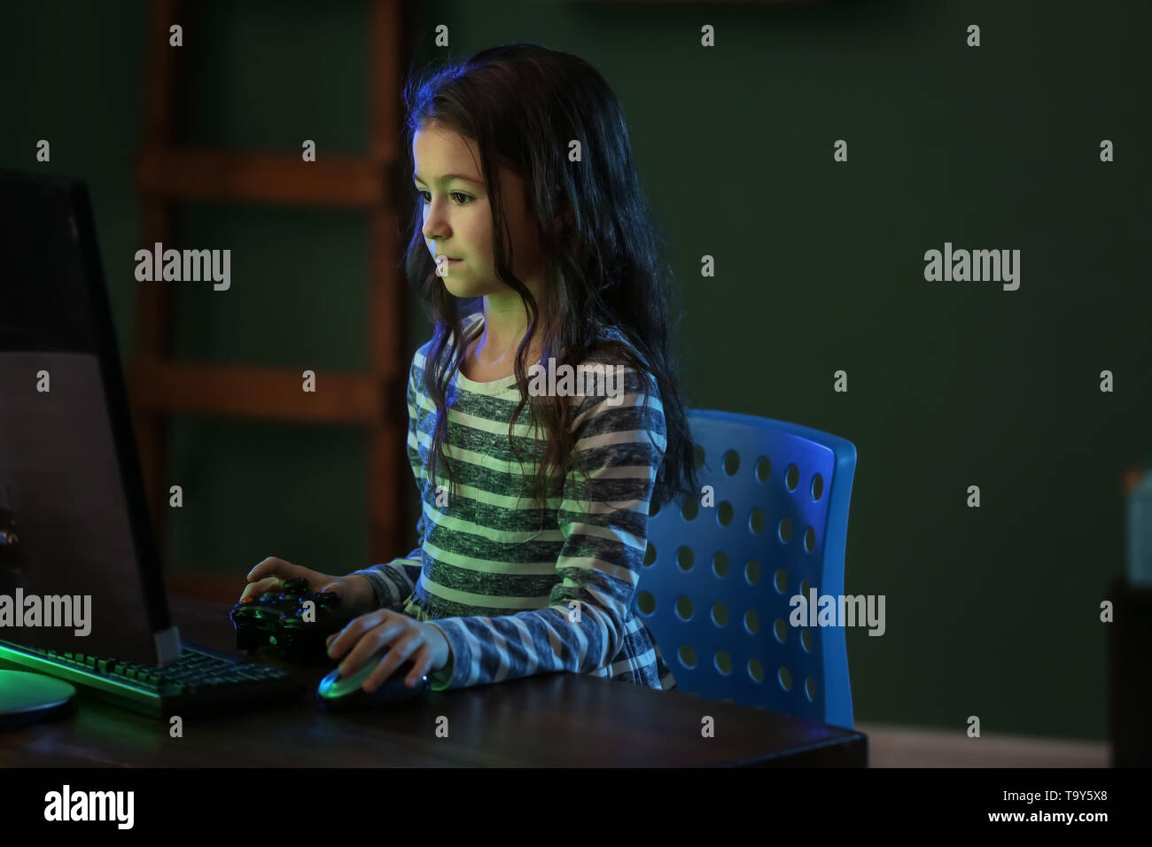 Cute little girl playing computer game at home Stock Photo - Alamy