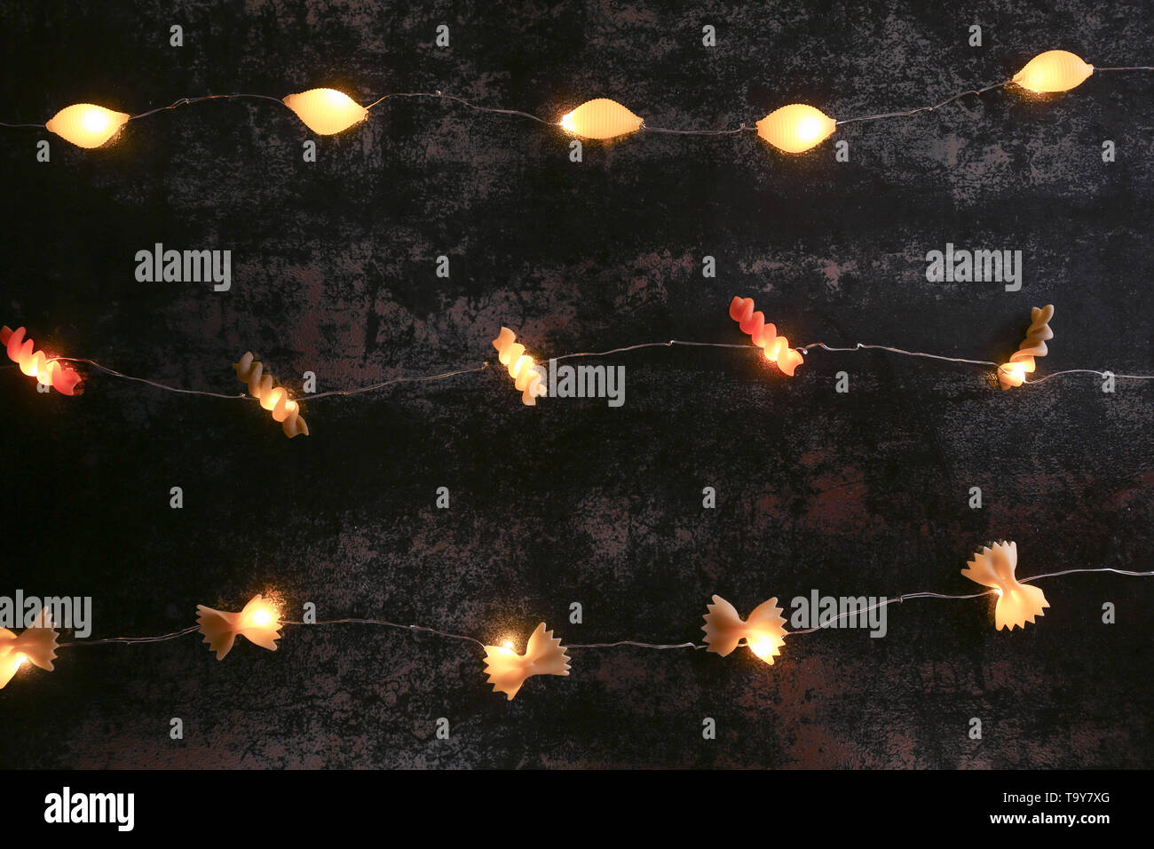 Illuminated garlands with different pasta on dark background Stock ...