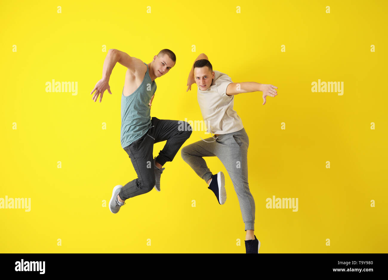 Jumping male dancers on color background Stock Photo - Alamy