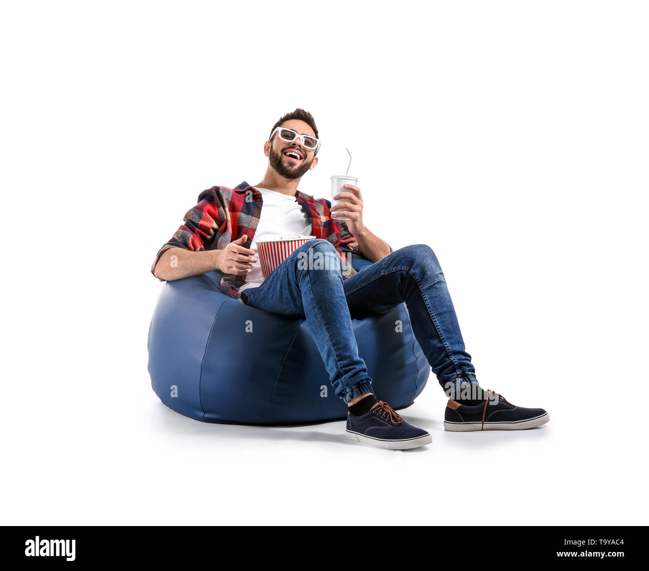 Young man with popcorn watching comedy movie on white background Stock ...