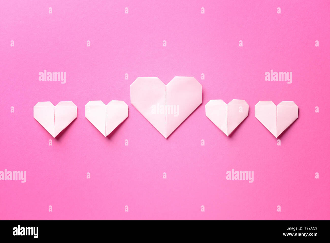 Origami hearts on color background Stock Photo - Alamy