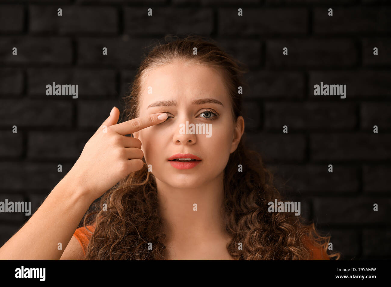 Portrait of woman with bad sight on dark brick background Stock Photo ...