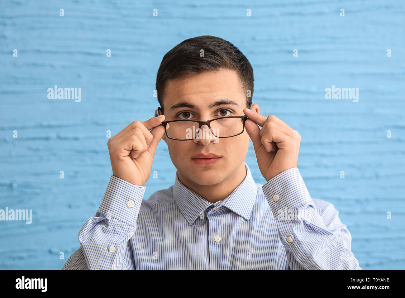 Portrait of man with bad sight on color background Stock Photo - Alamy