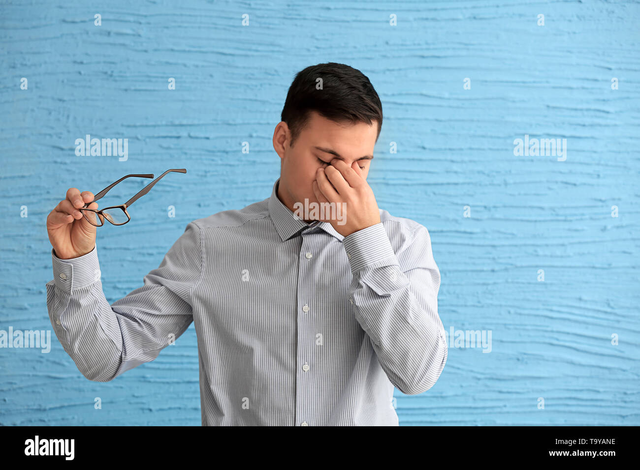 Portrait of man with bad sight on color background Stock Photo - Alamy