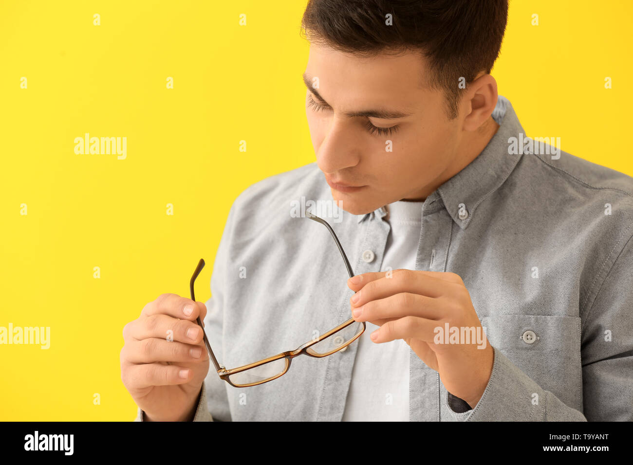 Portrait of man with bad sight on color background Stock Photo - Alamy