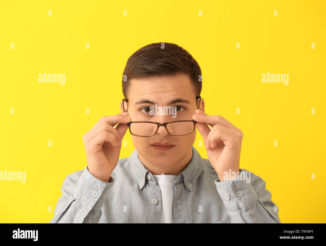 Portrait of man with bad sight on color background Stock Photo - Alamy