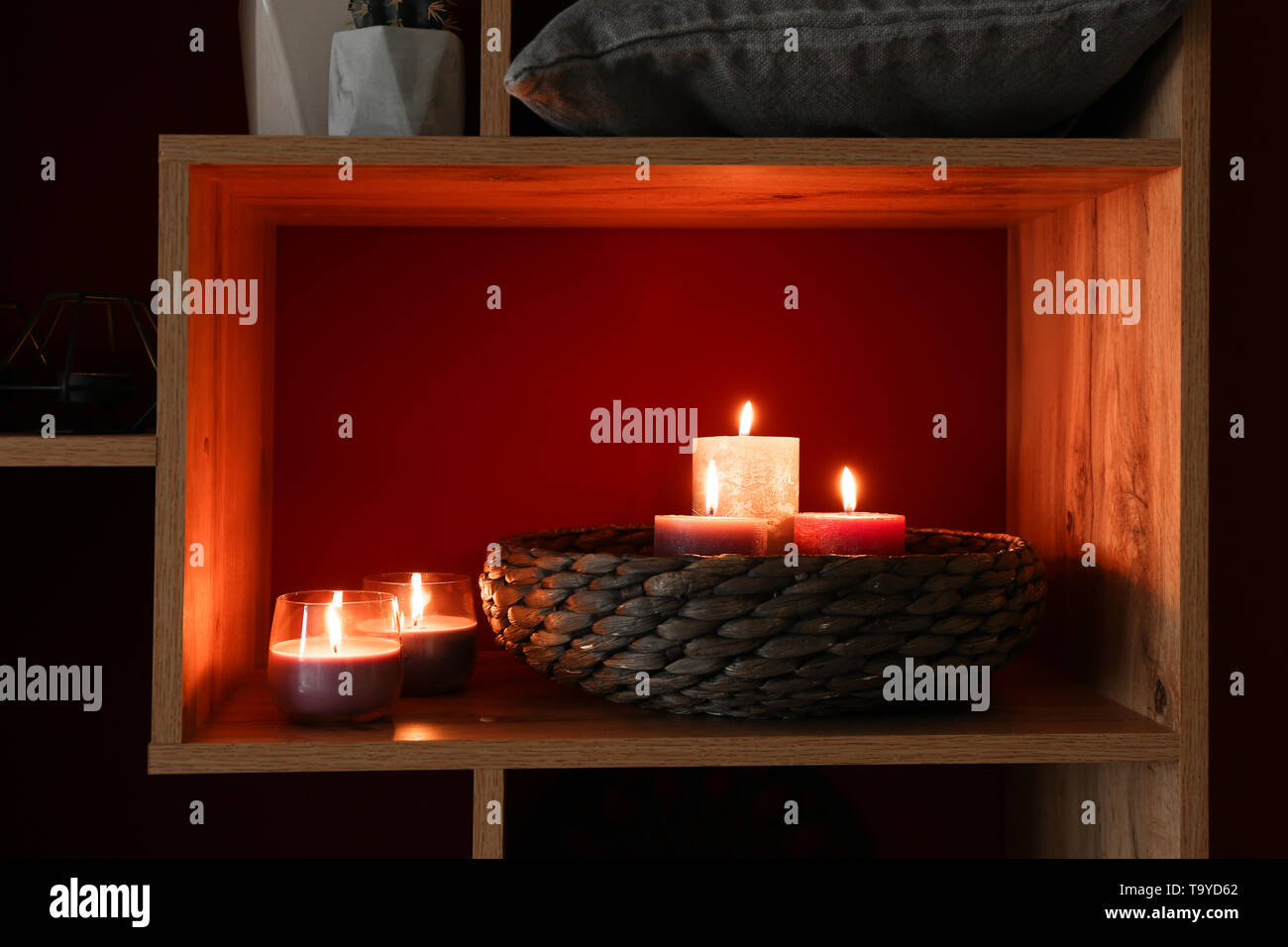 Beautiful burning candles on wooden shelf Stock Photo - Alamy