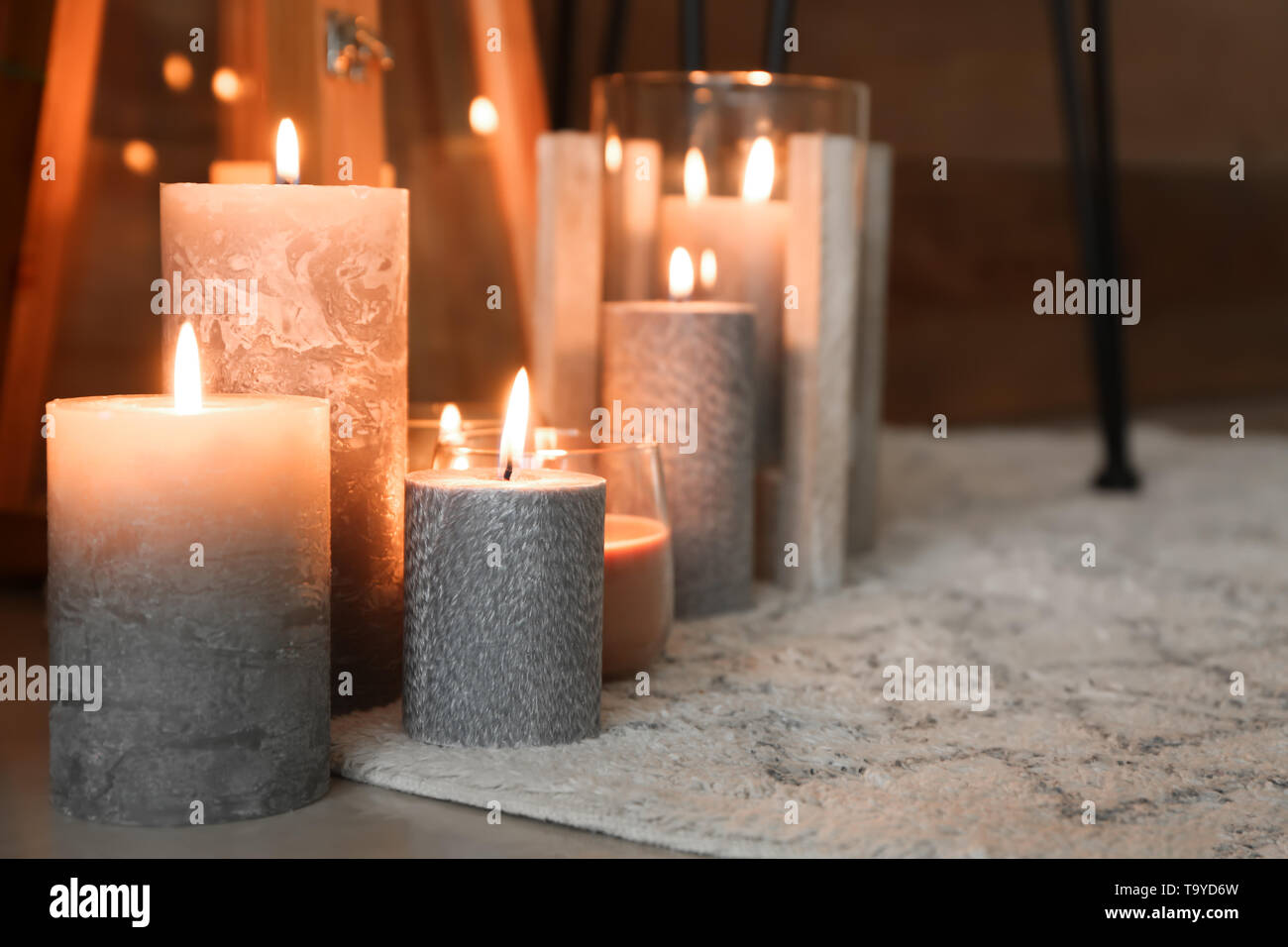 Beautiful burning candles on floor in room Stock Photo - Alamy