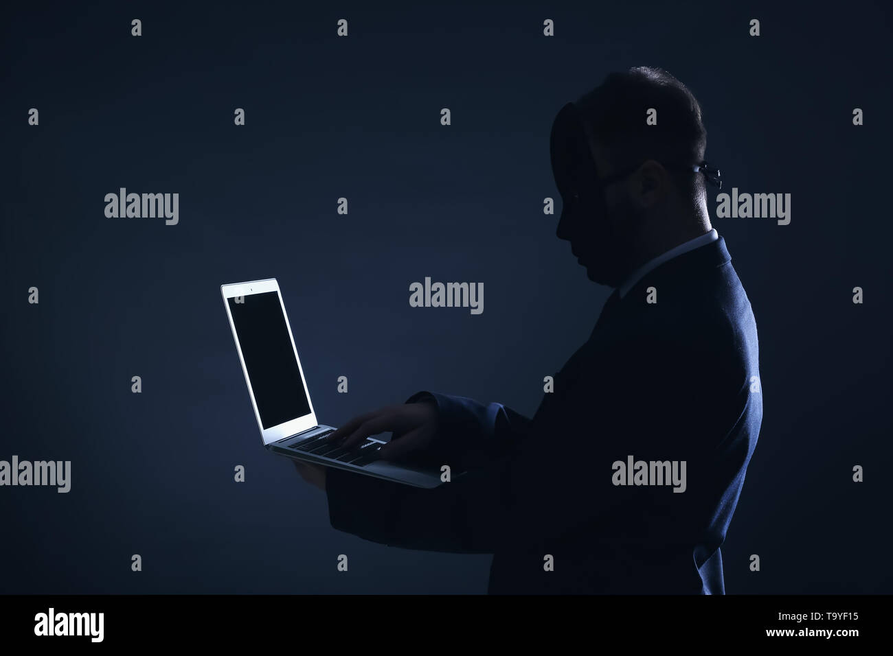 Professional hacker with laptop on dark background Stock Photo - Alamy