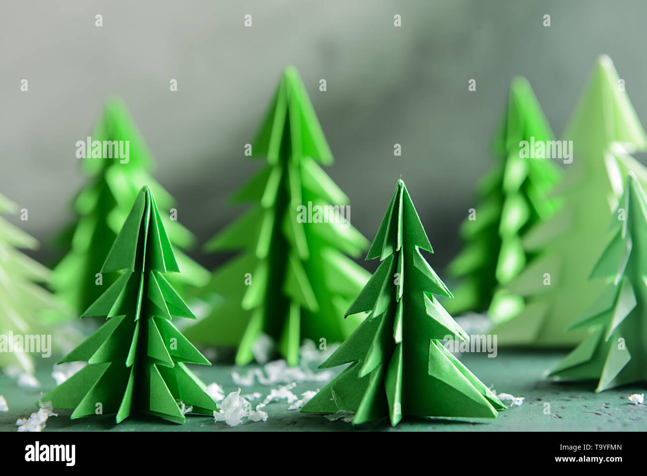 Origami fir trees with snow on color table Stock Photo - Alamy