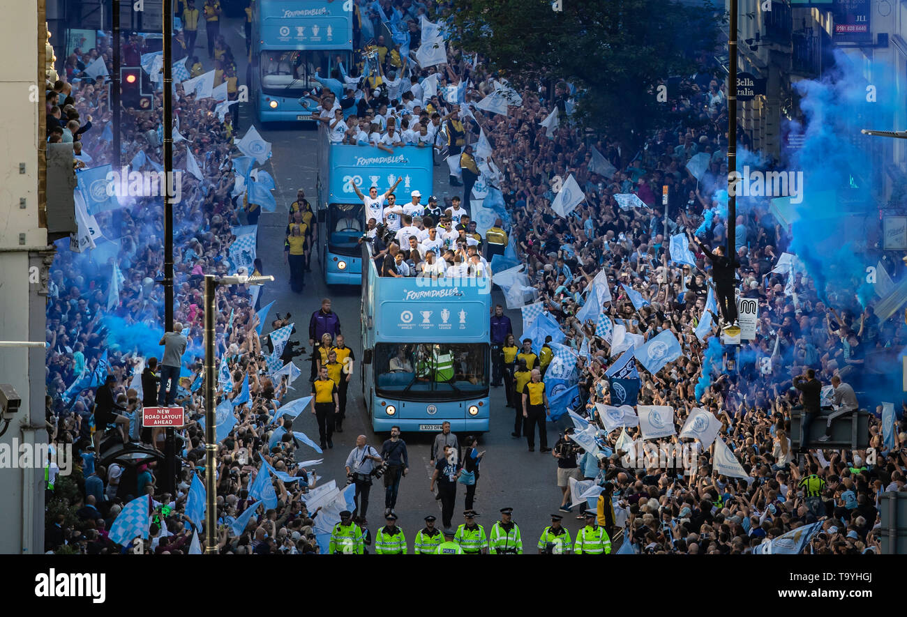 The Manchester City players and staff on the buses pass the crowds of ...