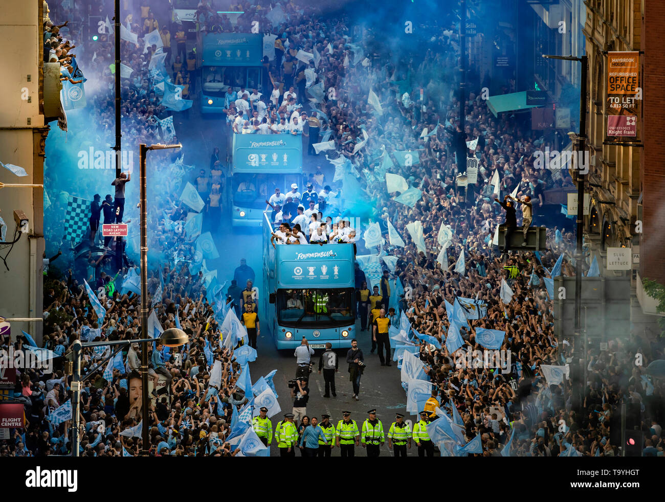 The Manchester City players and staff on the buses pass the crowds of ...
