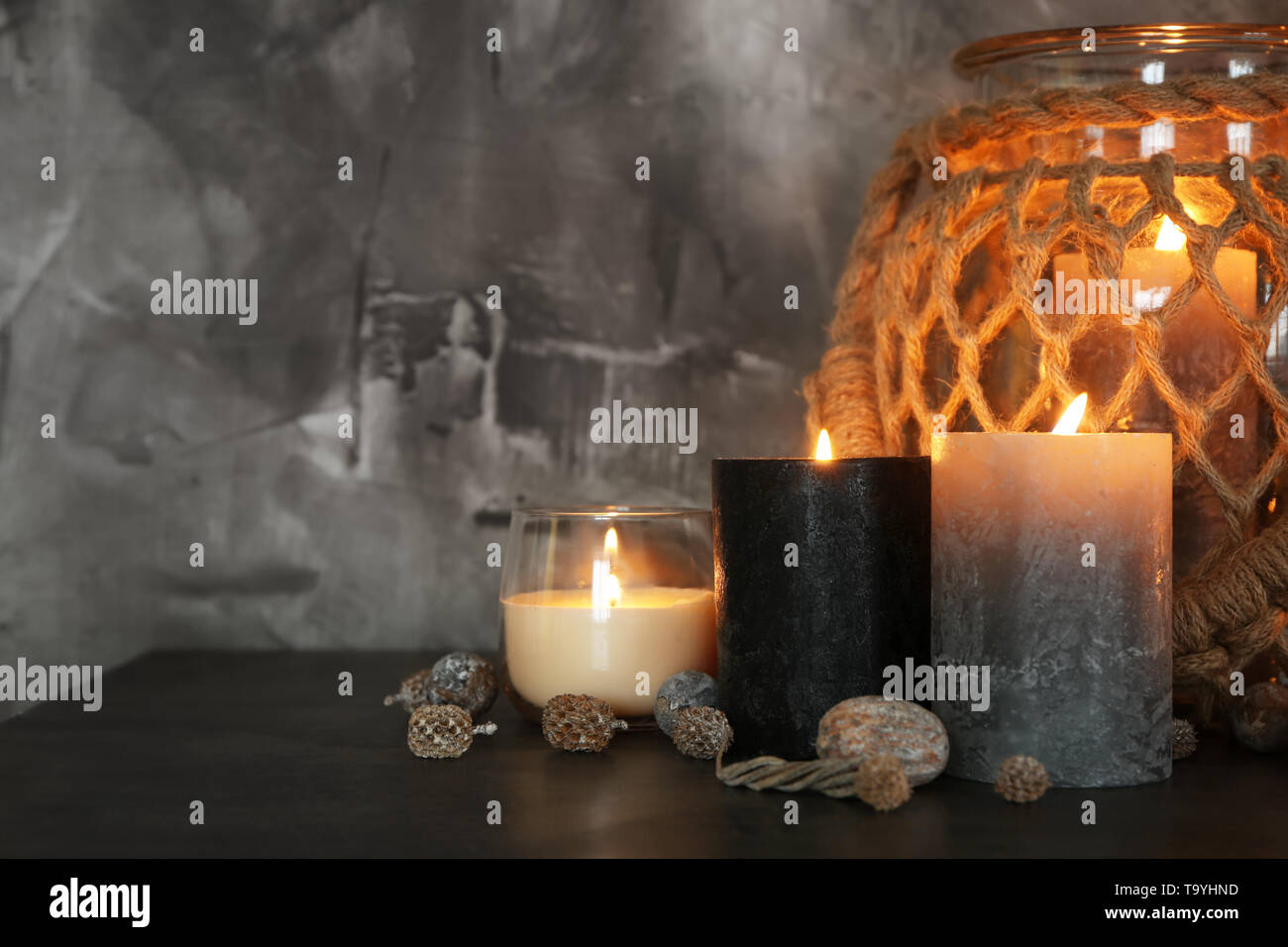 Beautiful burning candles on dark table Stock Photo - Alamy