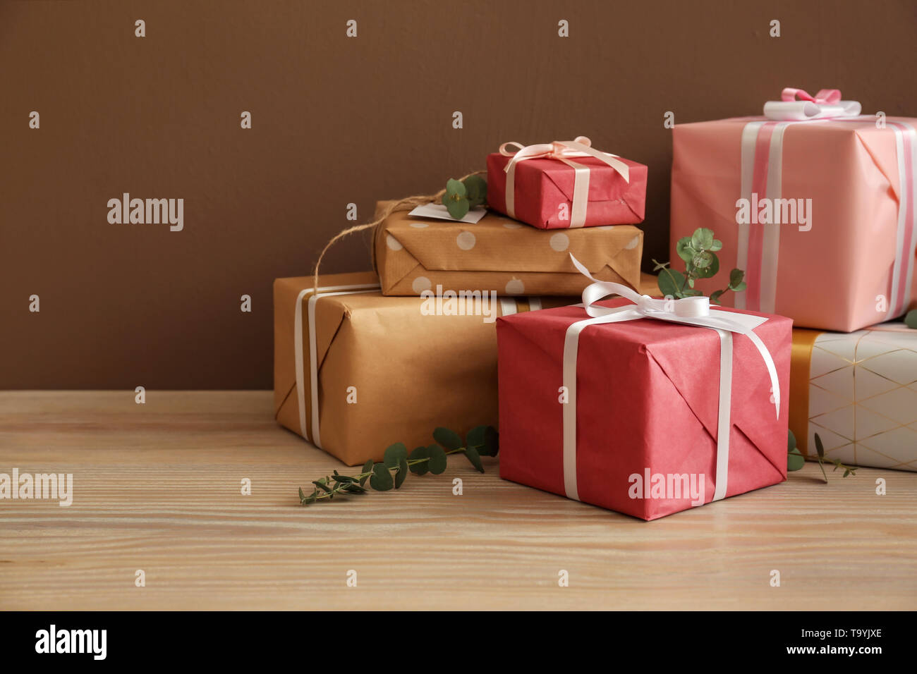 Festive gift boxes on table against color background Stock Photo - Alamy