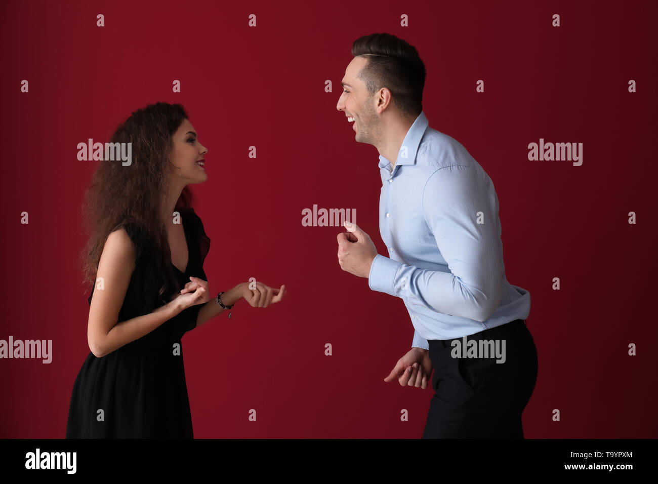 Young couple dancing against color background Stock Photo - Alamy