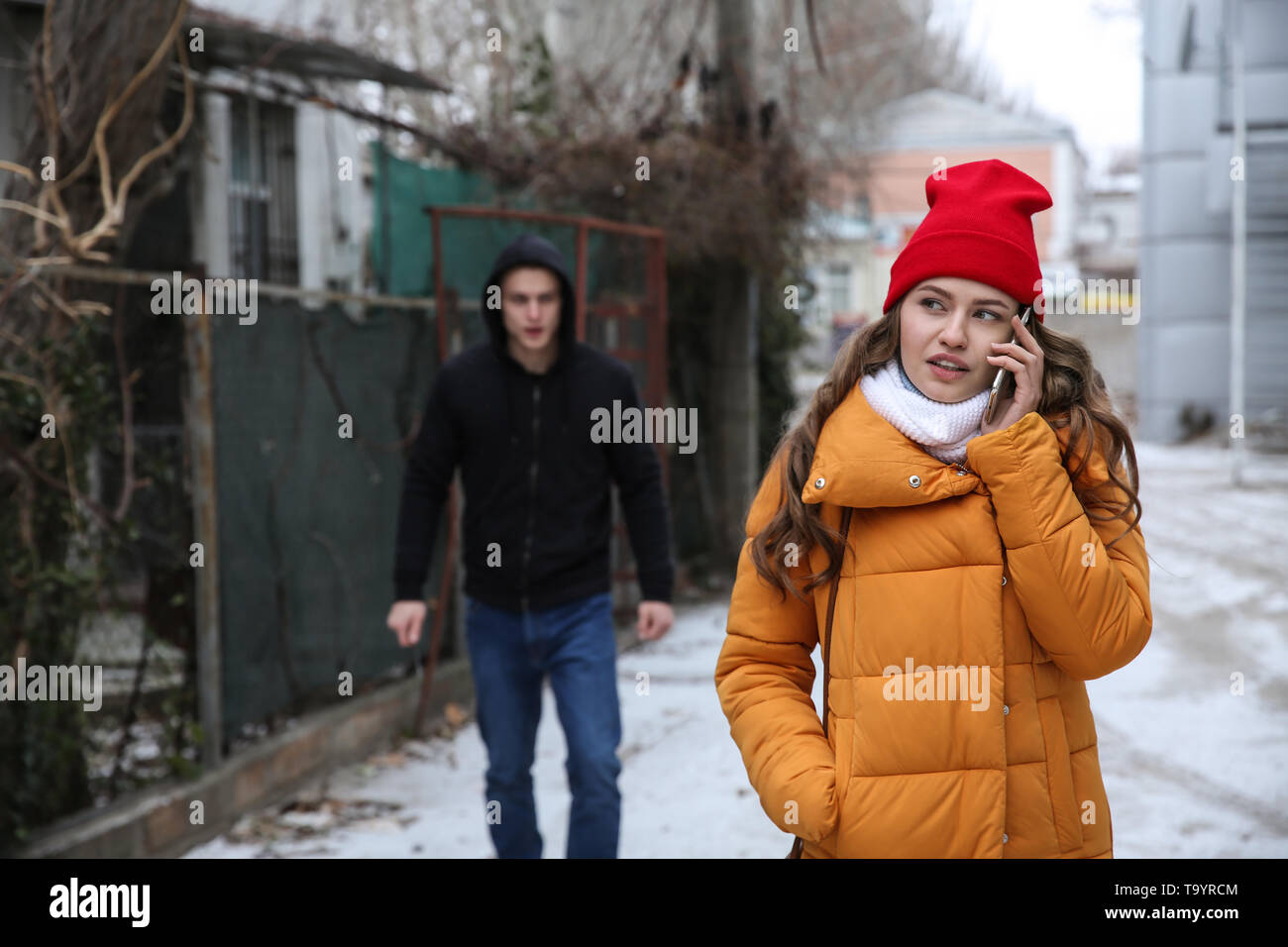 Male thief following young woman outdoors Stock Photo - Alamy
