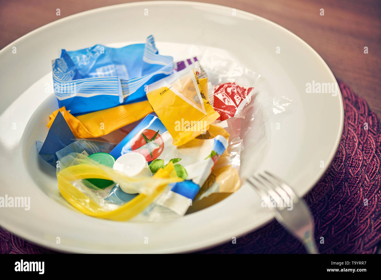 Plastic pollution of food concept Plate with plastic waste, bootle caps ...