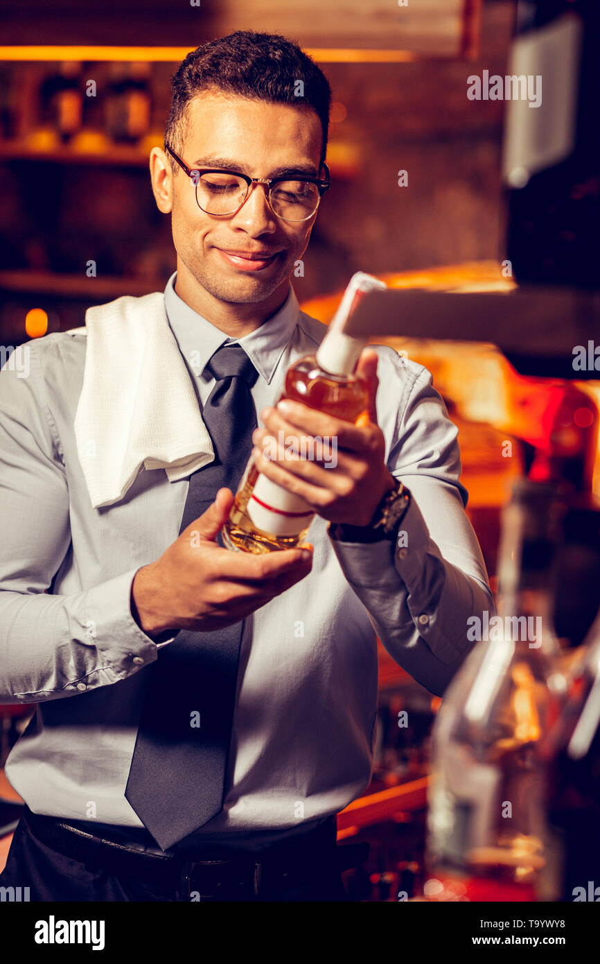 Rich man standing in his bar and holding bottle of alcohol Stock Photo ...
