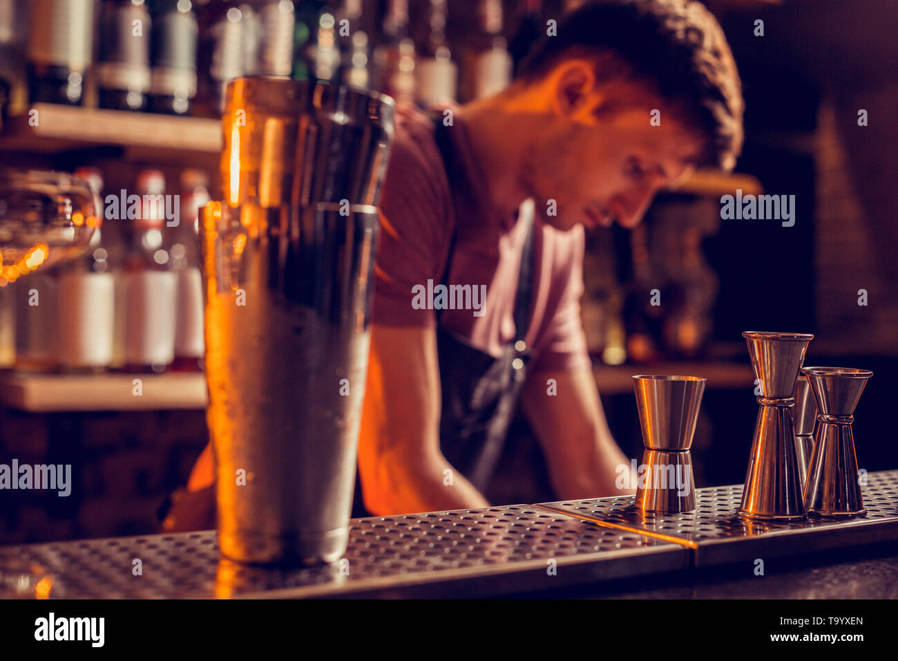 Young barman standing at the bar counter feeling busy Stock Photo - Alamy