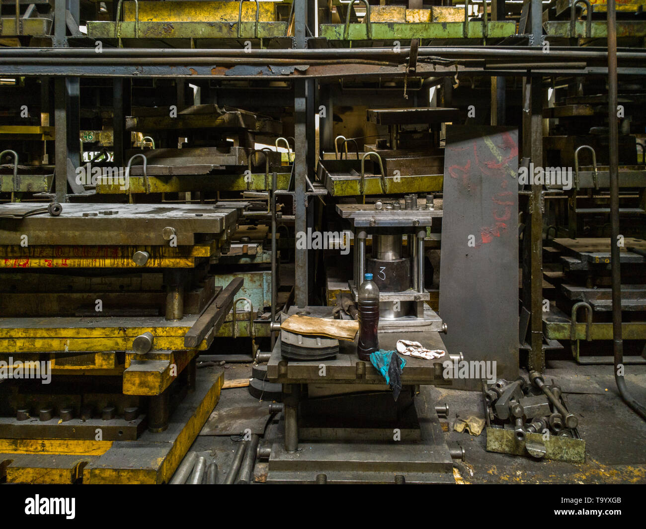 messy stamping shop with large stamps rack inside metalworking factory ...