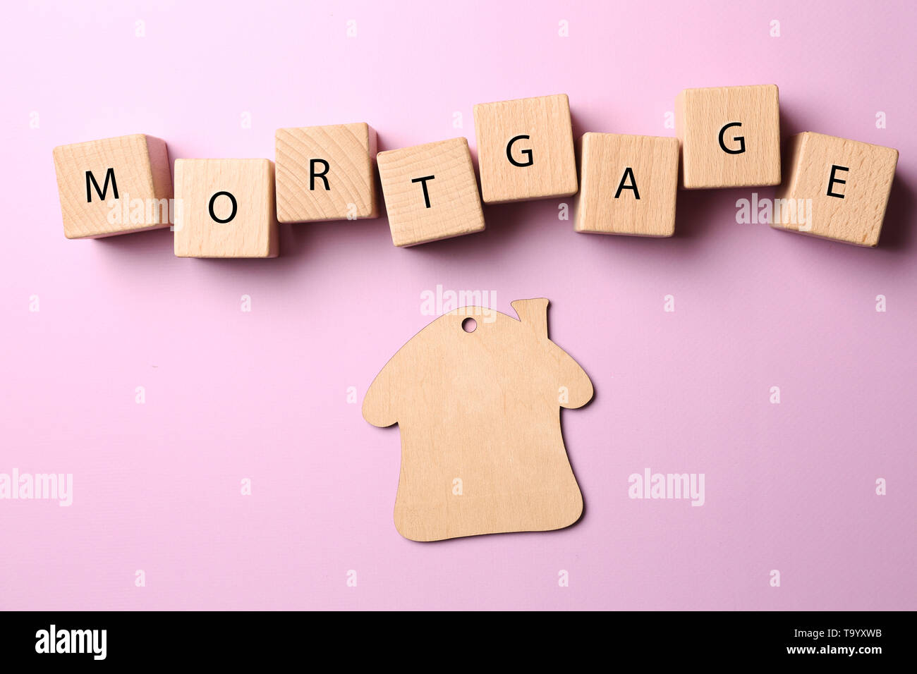 Figure of house and cubes forming word MORTGAGE on color background ...