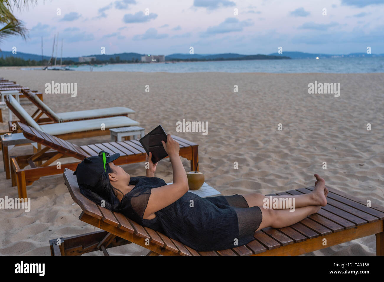 Young tourist use tablet on the beach Stock Photo - Alamy