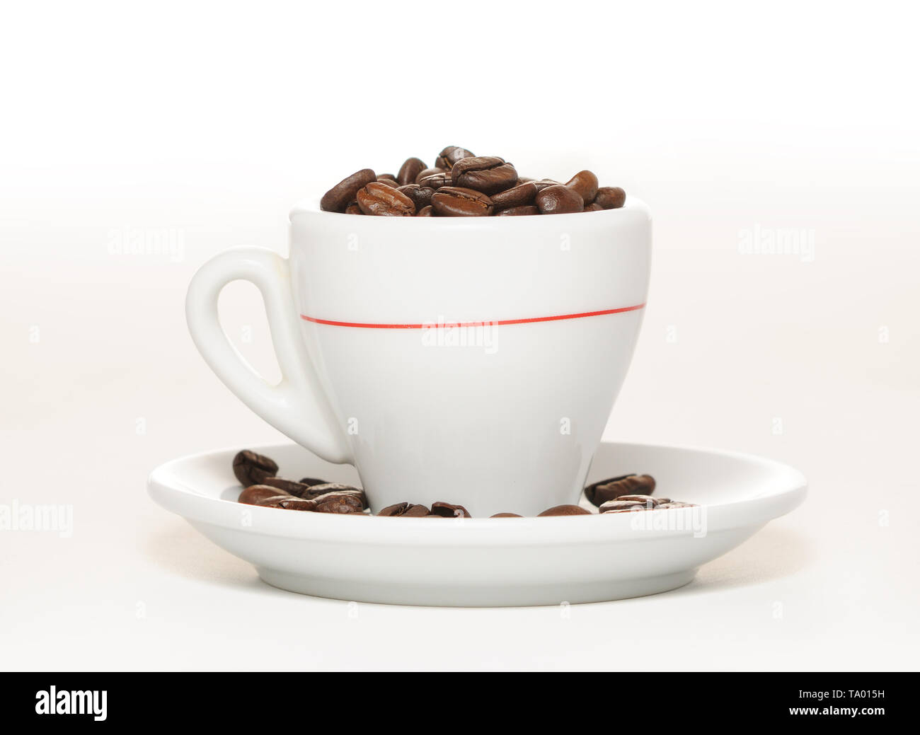 Cup with heap of coffee beans on white background Stock Photo - Alamy