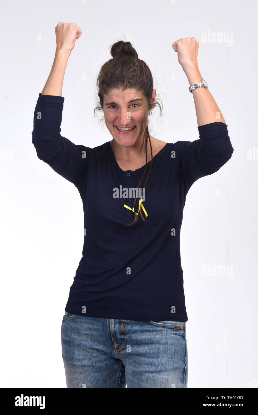 woman raising her arms and smiling in victory sign on white background ...