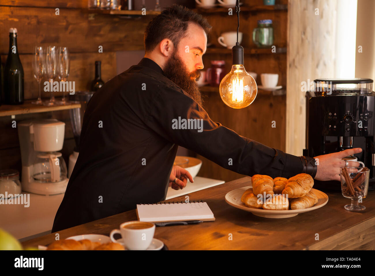 Handsome barman behind a bar with a prepared coffee. Vintage pub Stock ...