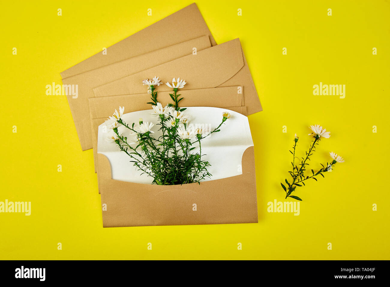 Gold envelope with a spring flower arrangement on yellow background ...