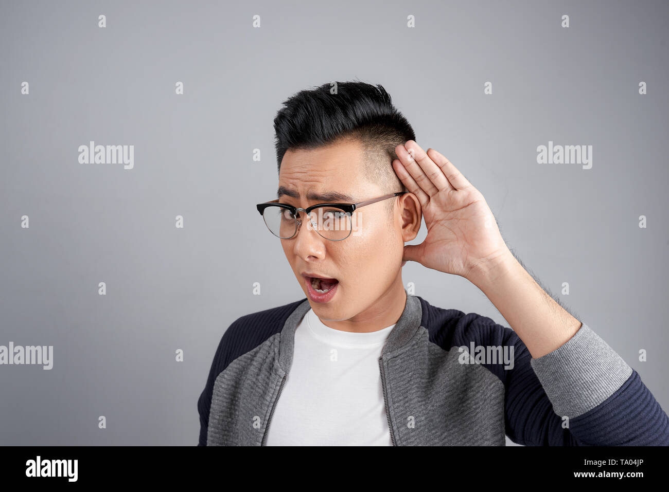 Portrait of young casual man which overhears conversation over white ...