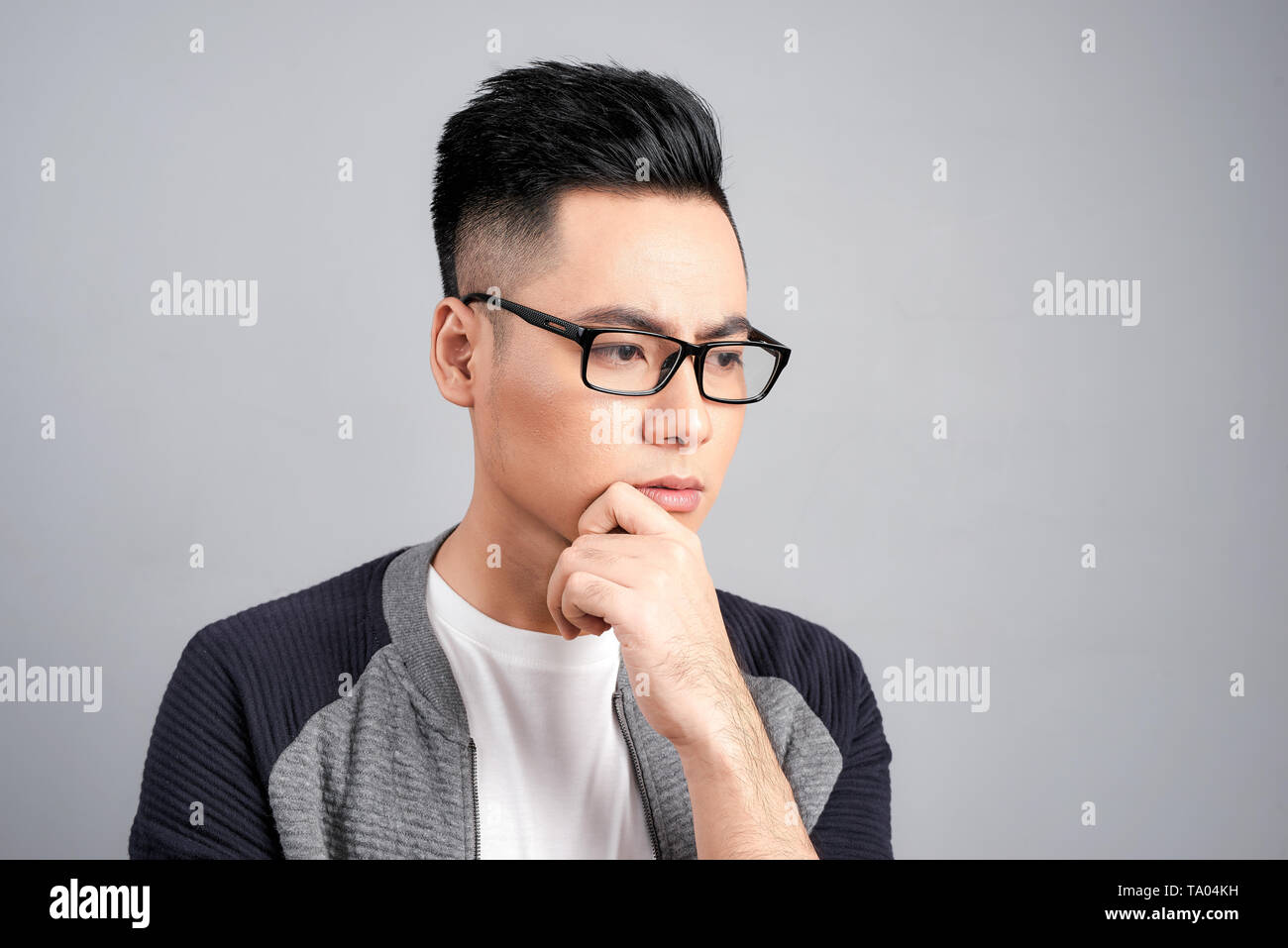 Studio shot of young Asian man thinking while wearing eyeglasses Stock ...